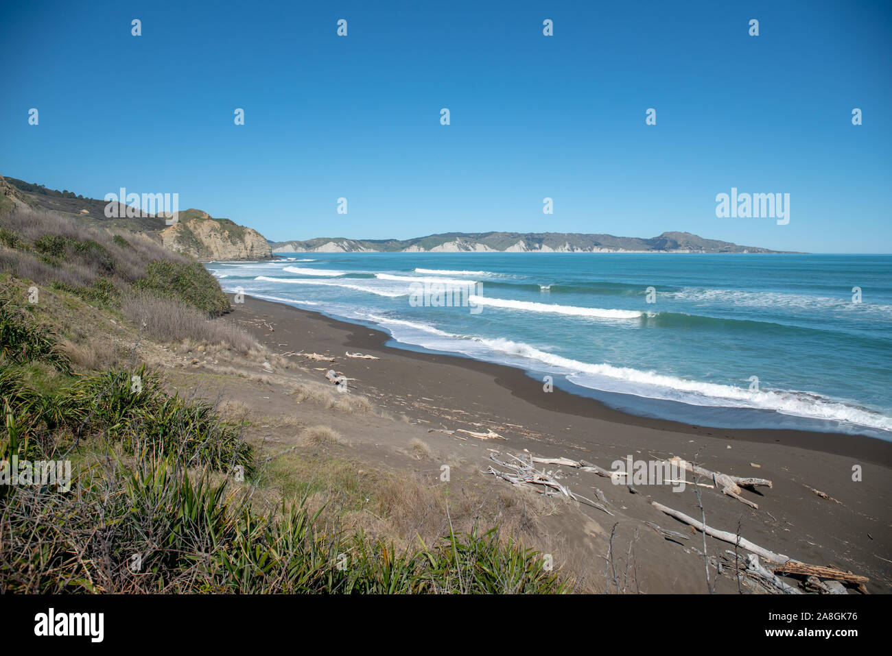 surf waves rolling in at the deserted empty coastal beach in Gisborne ...
