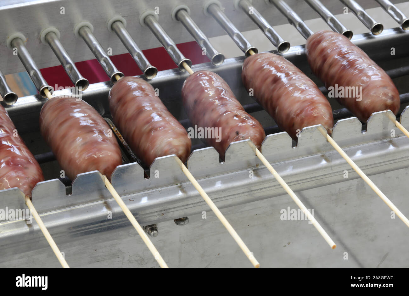 special rotating spit with many sausage of pork Stock Photo - Alamy