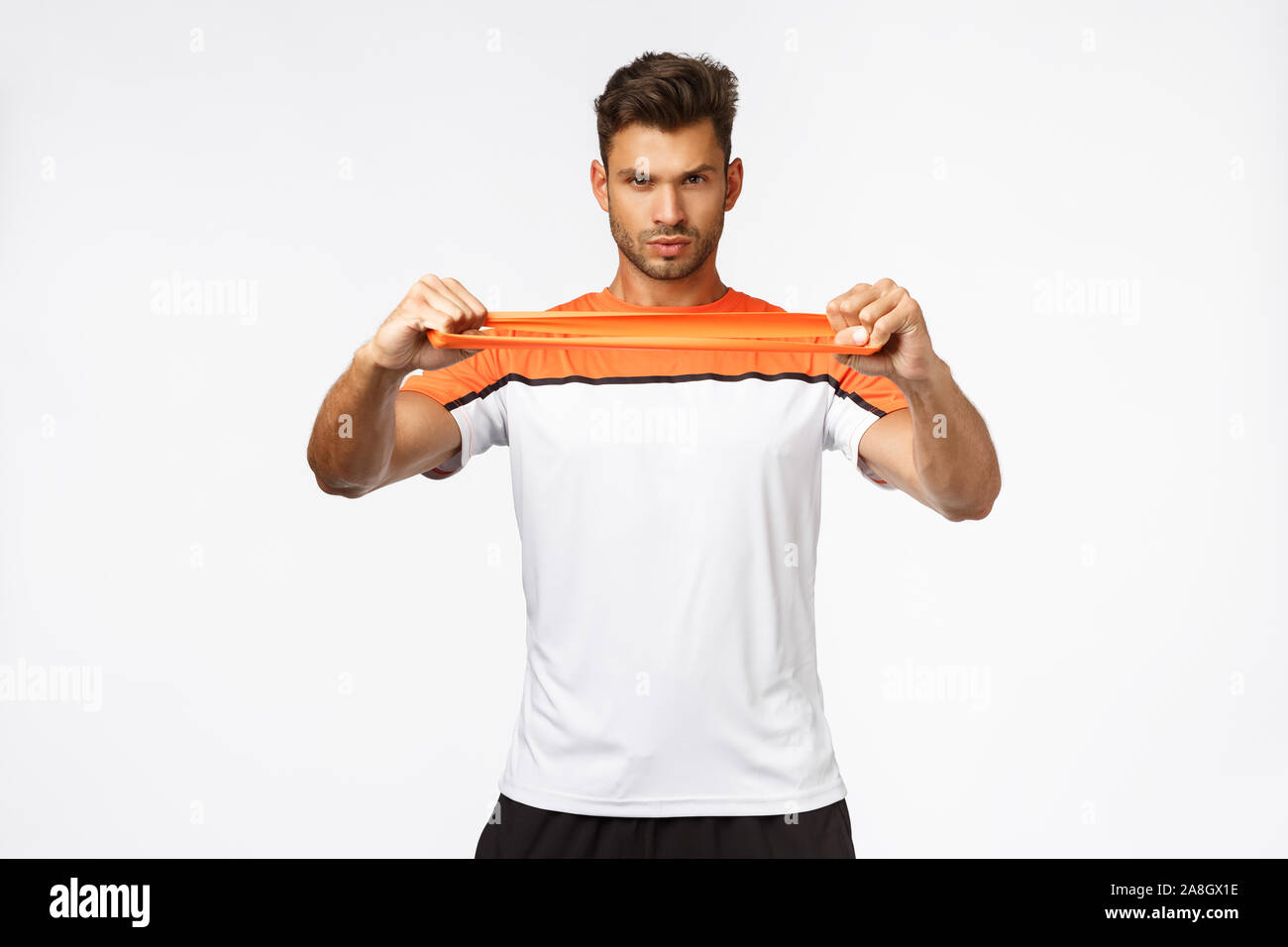 Serious, determined and motivated handsome sportsman using orange ...