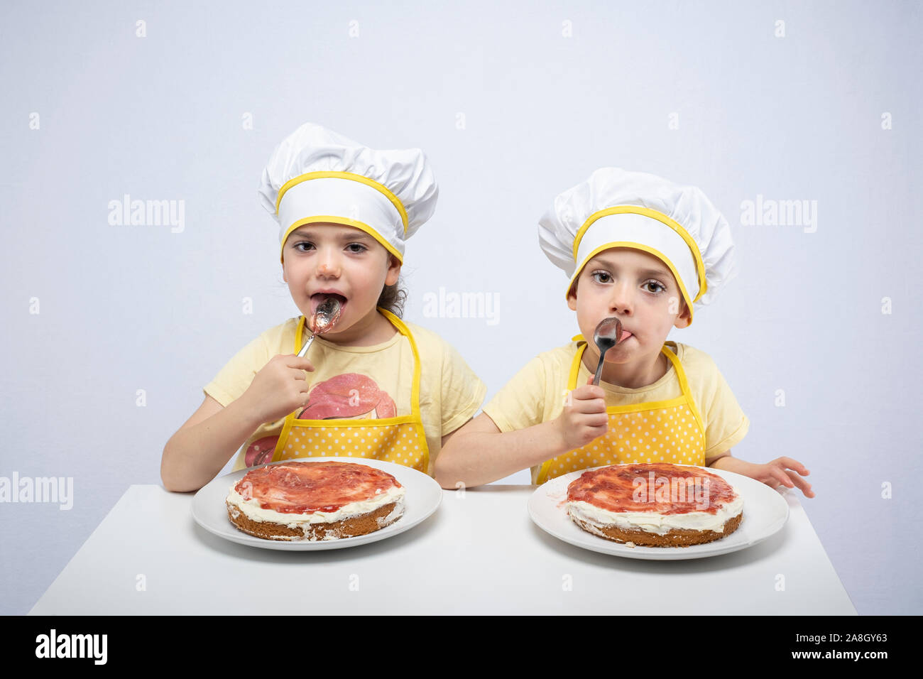 Young sisters, baking a cake together in the studio Stock Photo - Alamy