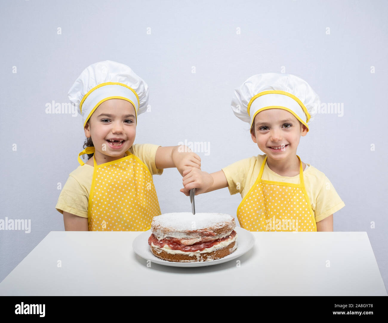 Young sisters, baking a cake together in the studio Stock Photo - Alamy