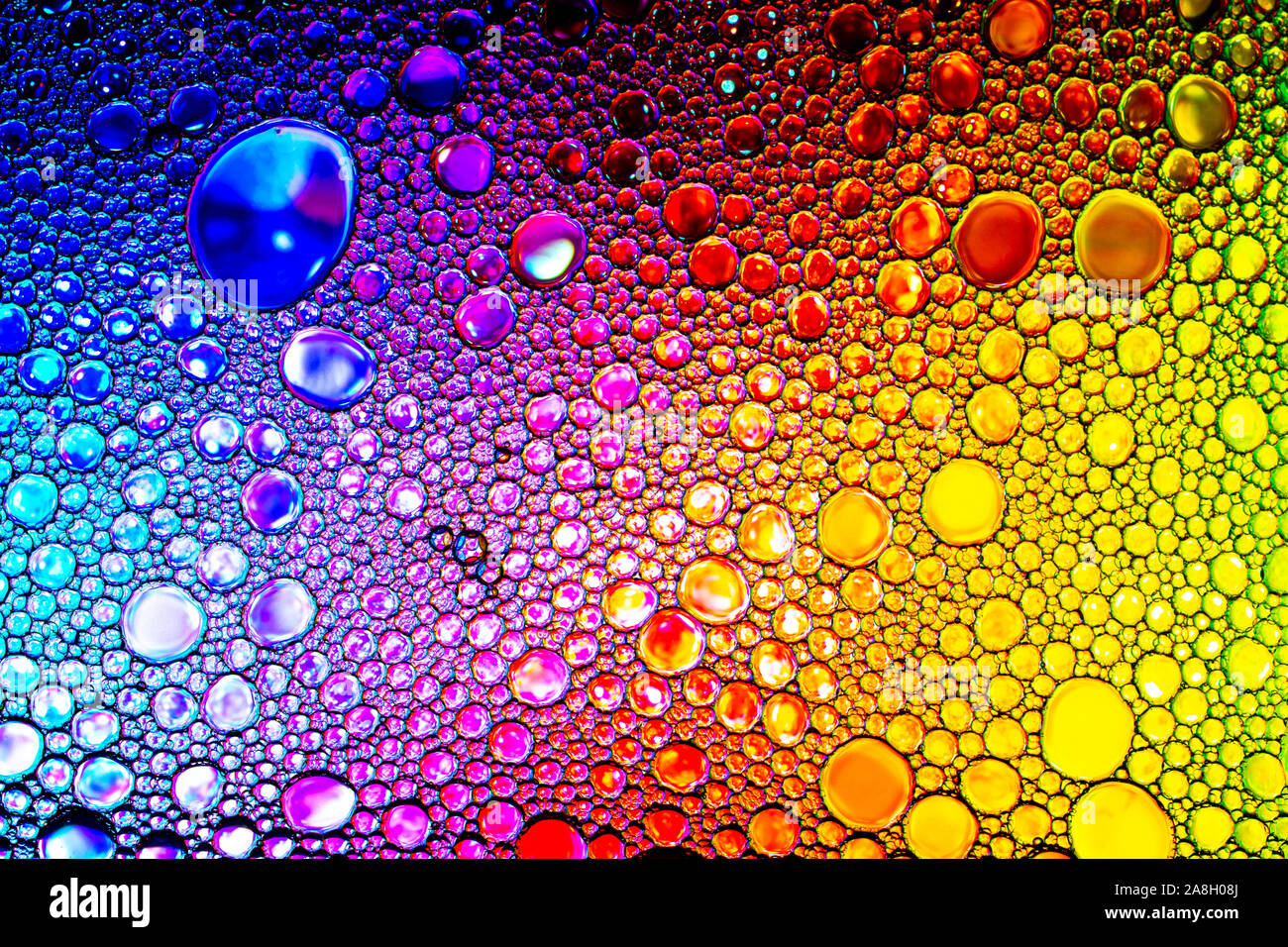 Colorful drops of oil on the water. Rainbow or spectrum colored circles ...