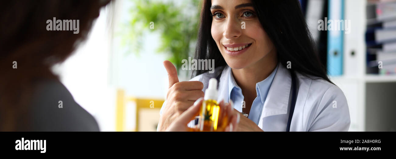 Female GP giving patient dropper jar of cannabis concentrate oil Stock ...