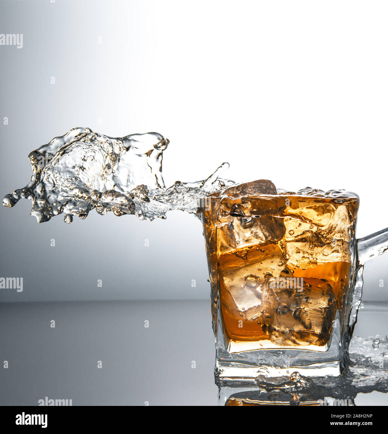 a glass with ice and liquid splash Stock Photo - Alamy