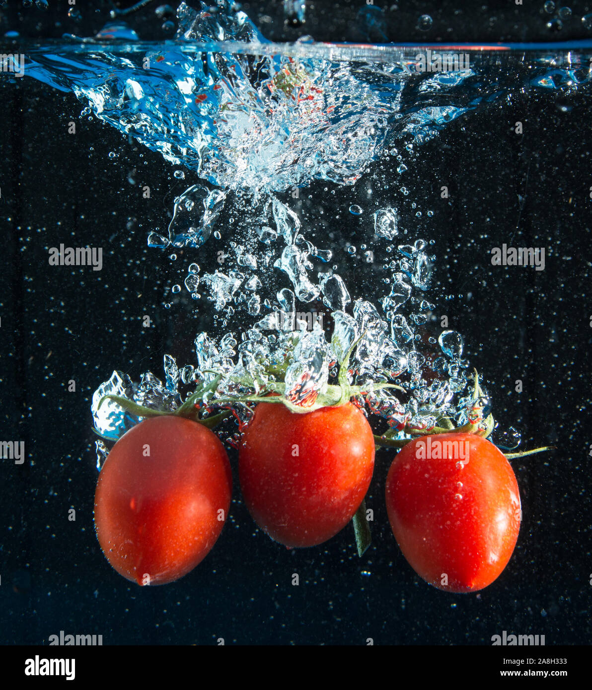 Tomatoes falling on wet black hi-res stock photography and images - Alamy