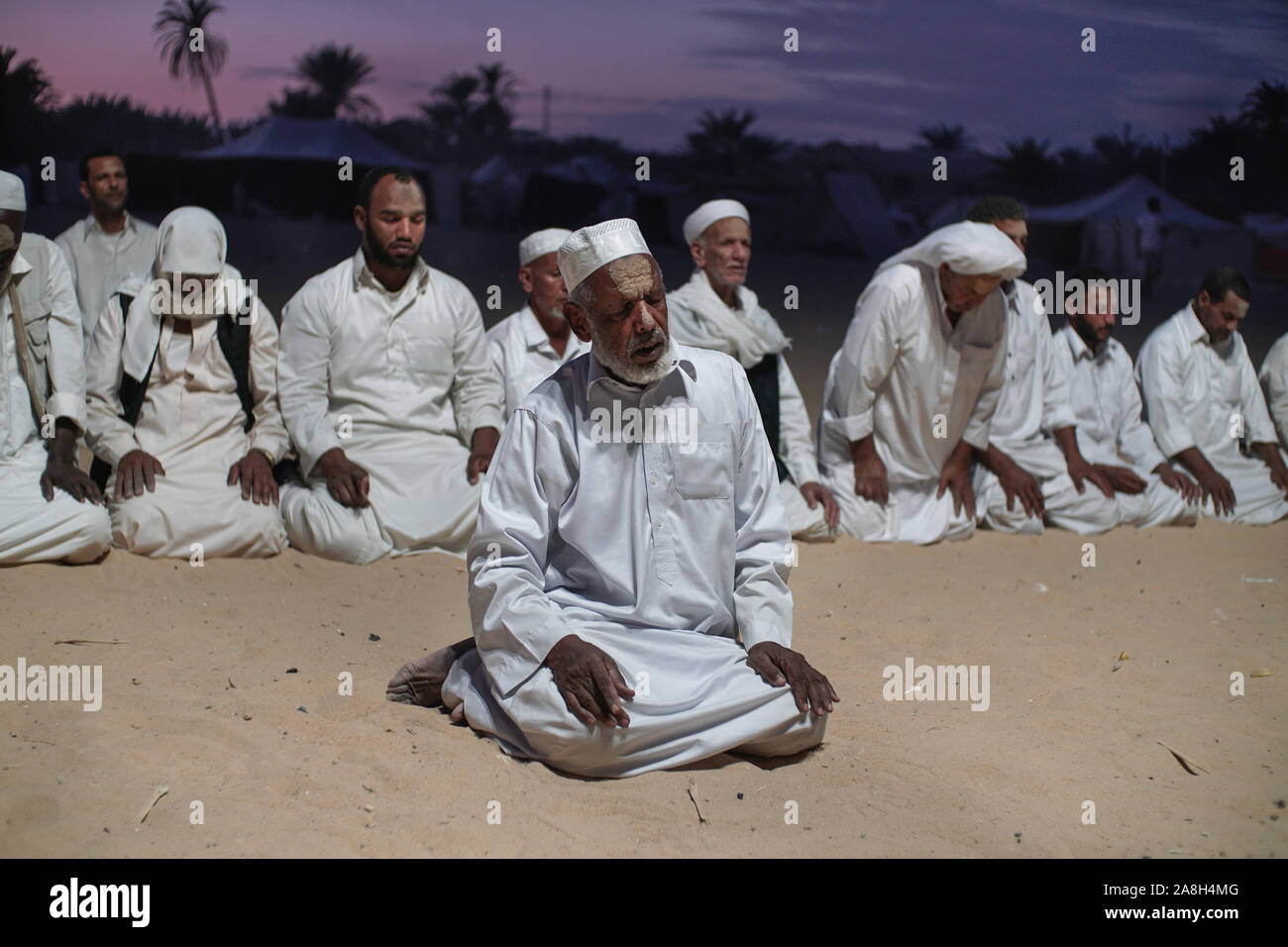 Senior males pray in the desert of Siwa Oasis Stock Photo - Alamy
