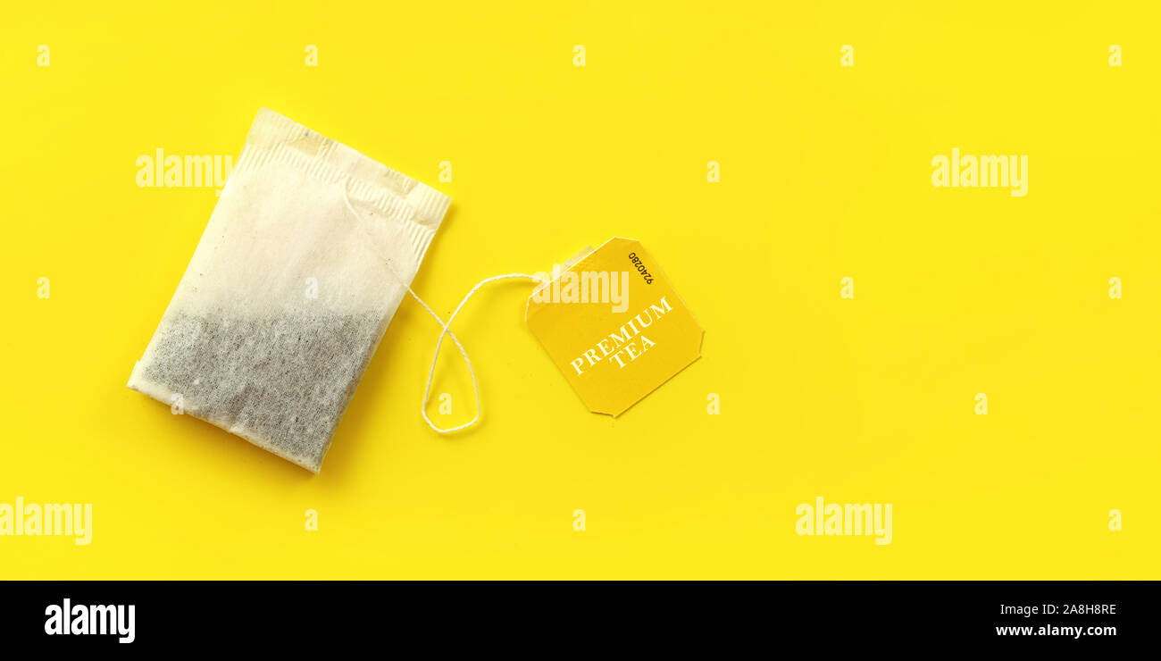 Top down view, tea bag on yellow board, wide banner with space for text ...