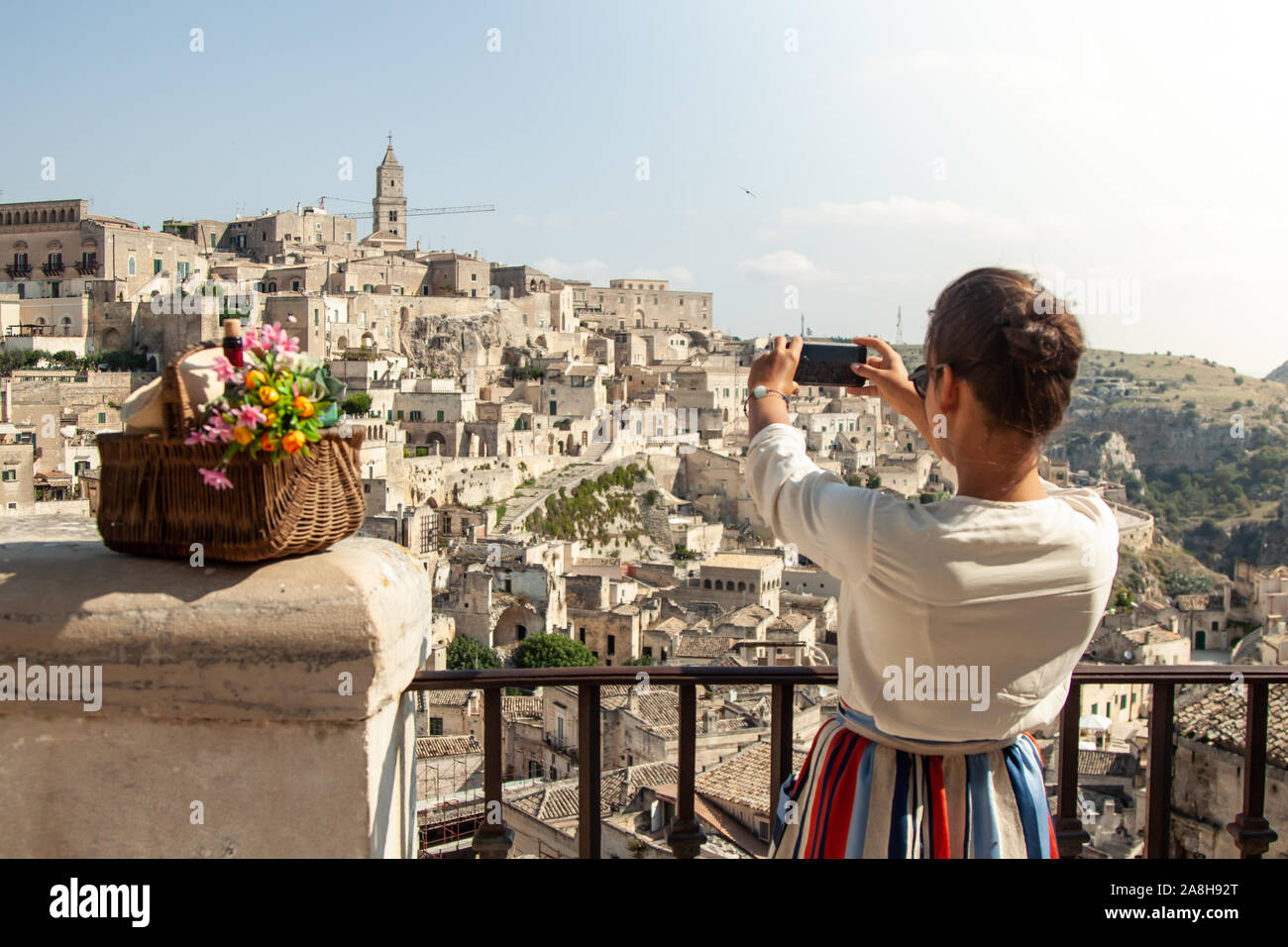 Young elegant woman tourist in historical Matera town in Italy taking ...