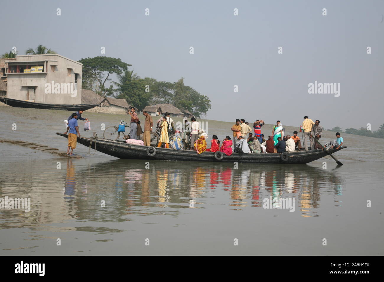 Wooden boat crosses the Ganges River in Gosaba, West Bengal, India ...