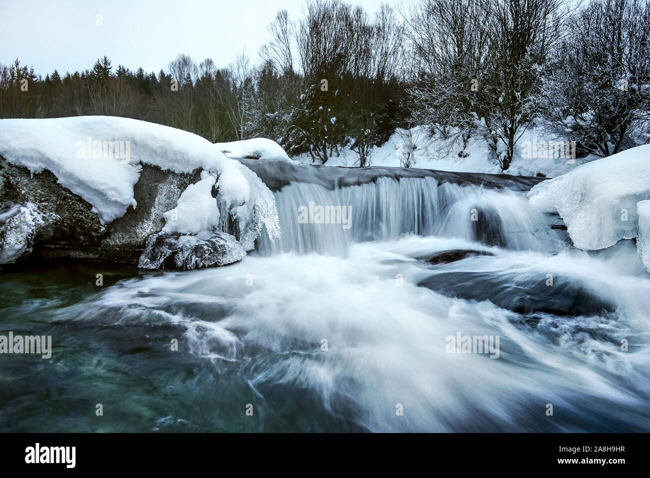 River covered with snow and ice in winter, trees background, long ...