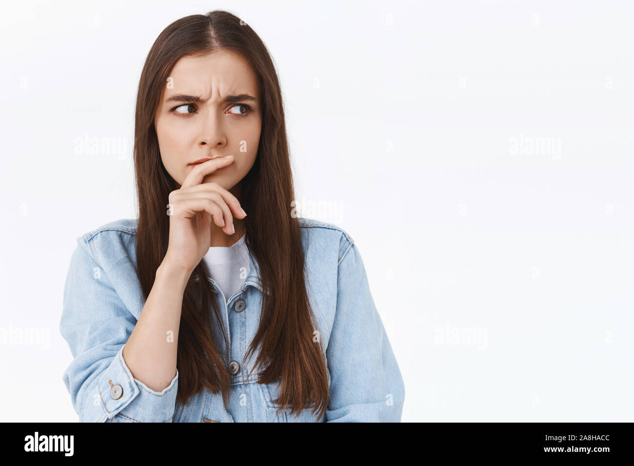Pensive, serious-looking focused caucasian woman in denim jacket ...