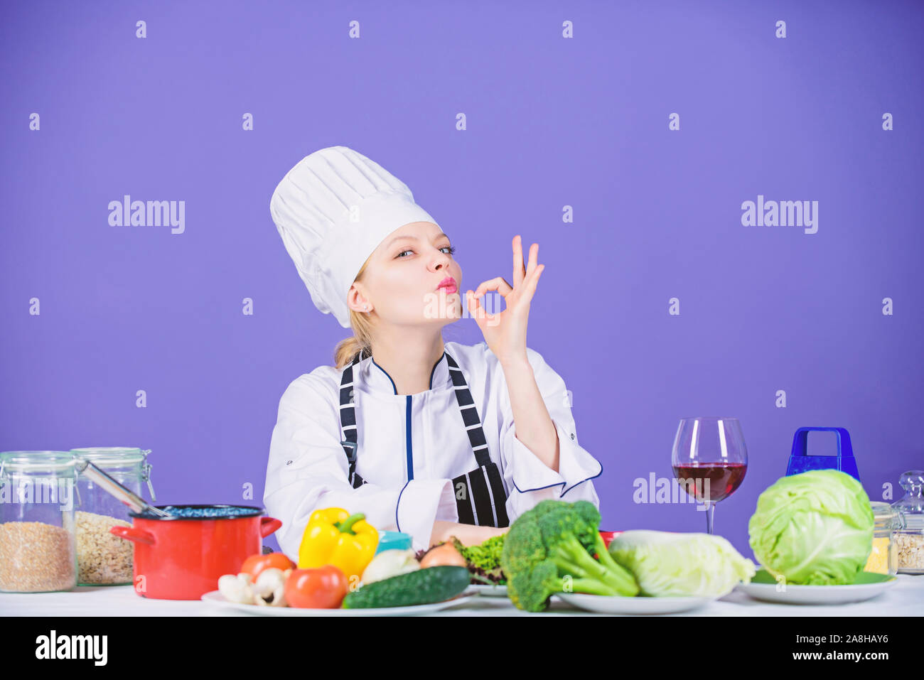 Yummy cooking. Kitchen maid showing OK gesture. Pretty woman cooking in ...