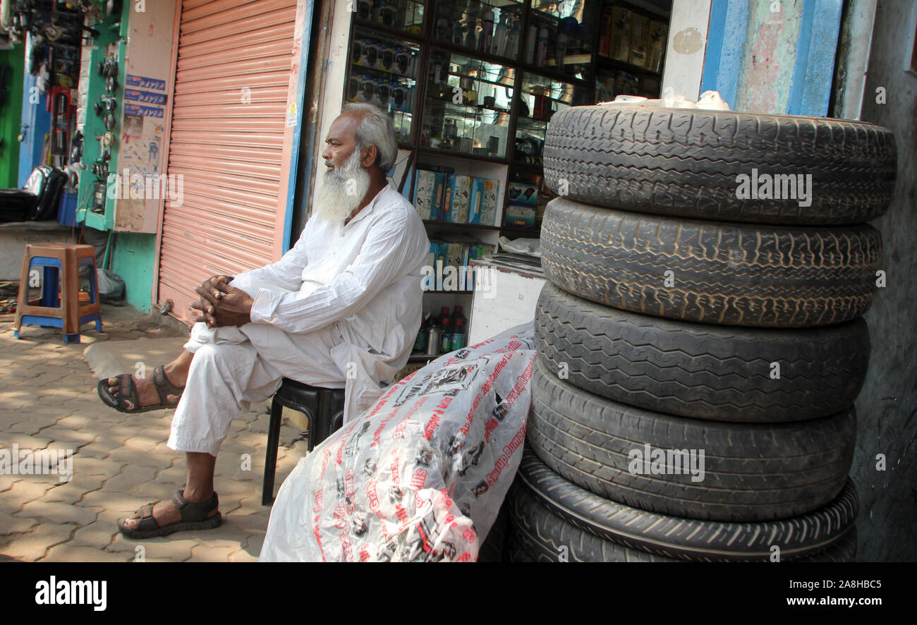 Indian man outside a shop selling car parts on Malik bazar in Kolkata ...