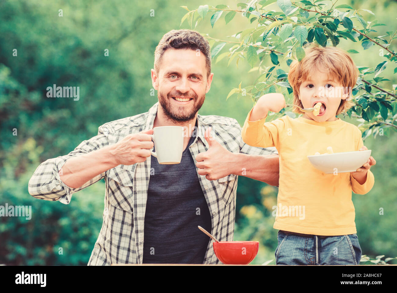 Father son eat food and have fun. Little boy and dad eating. Nutrition ...