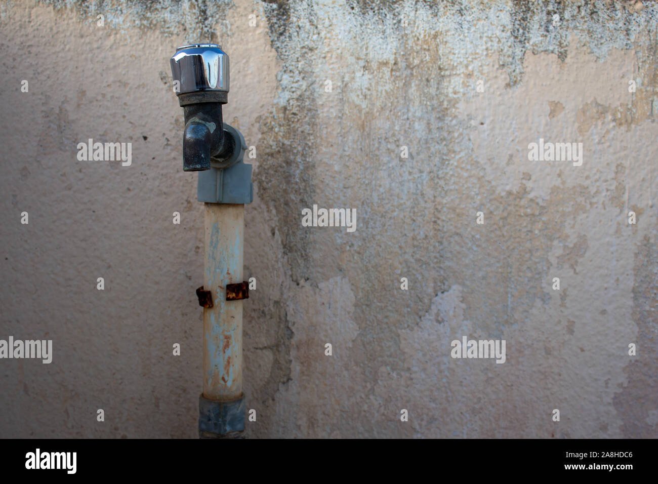 Chrome Water tap attached to wall in building exterior Stock Photo - Alamy