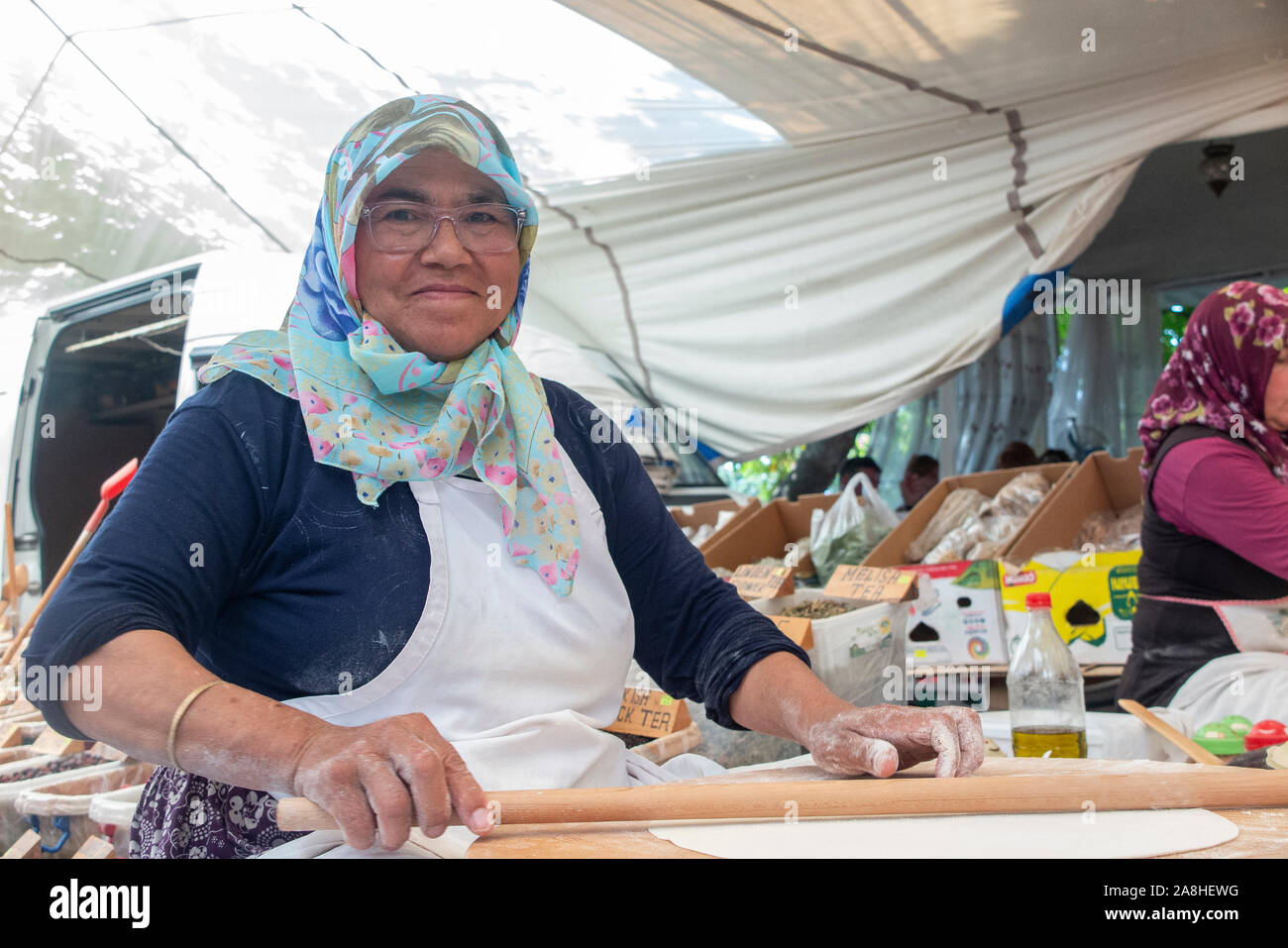 A beautiful, elderly lady prepares food in a tent in a village in ...