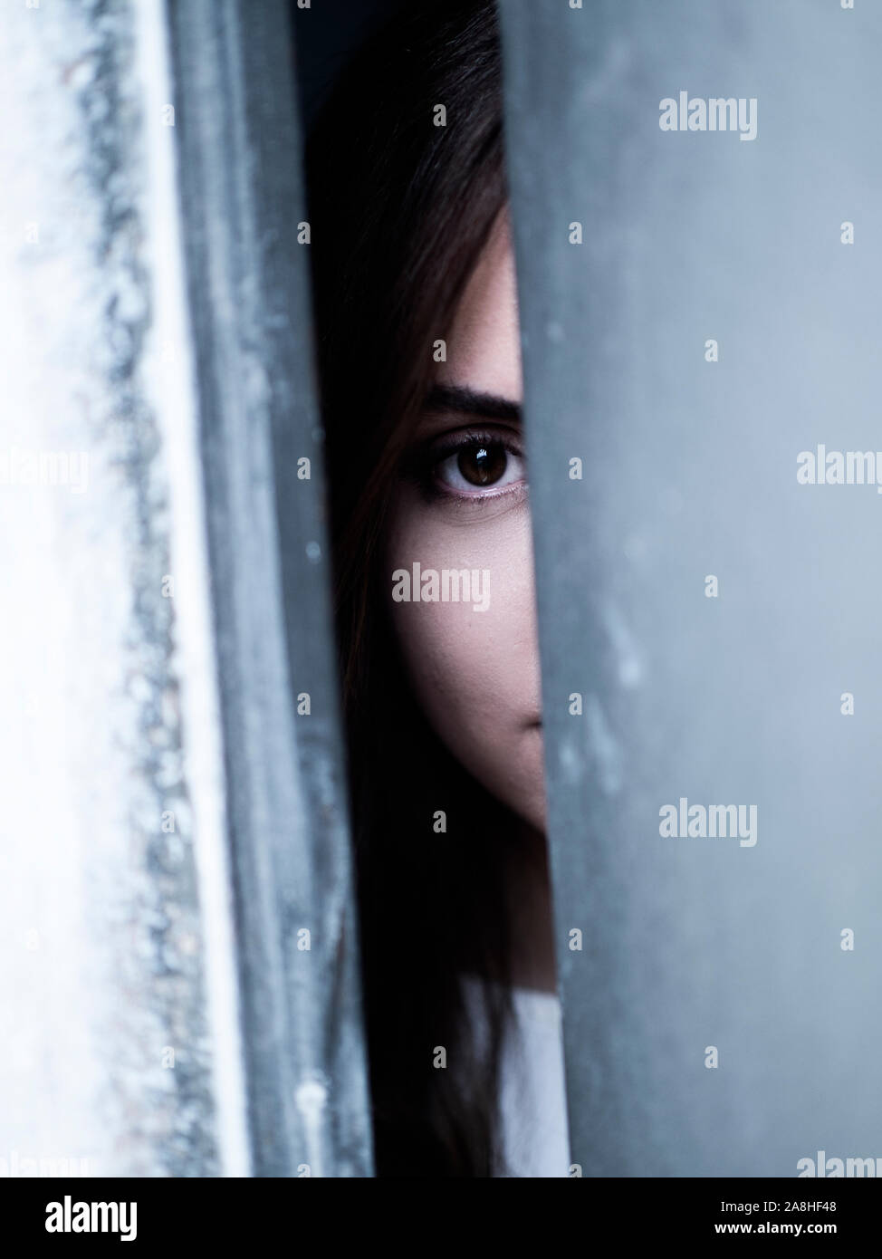 Beautiful young woman peeking Stock Photo - Alamy