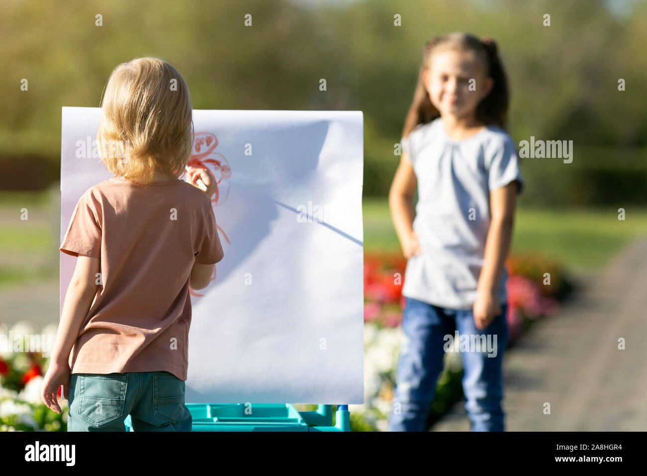 Brother and sister paint funny portraits of people with paints paper ...