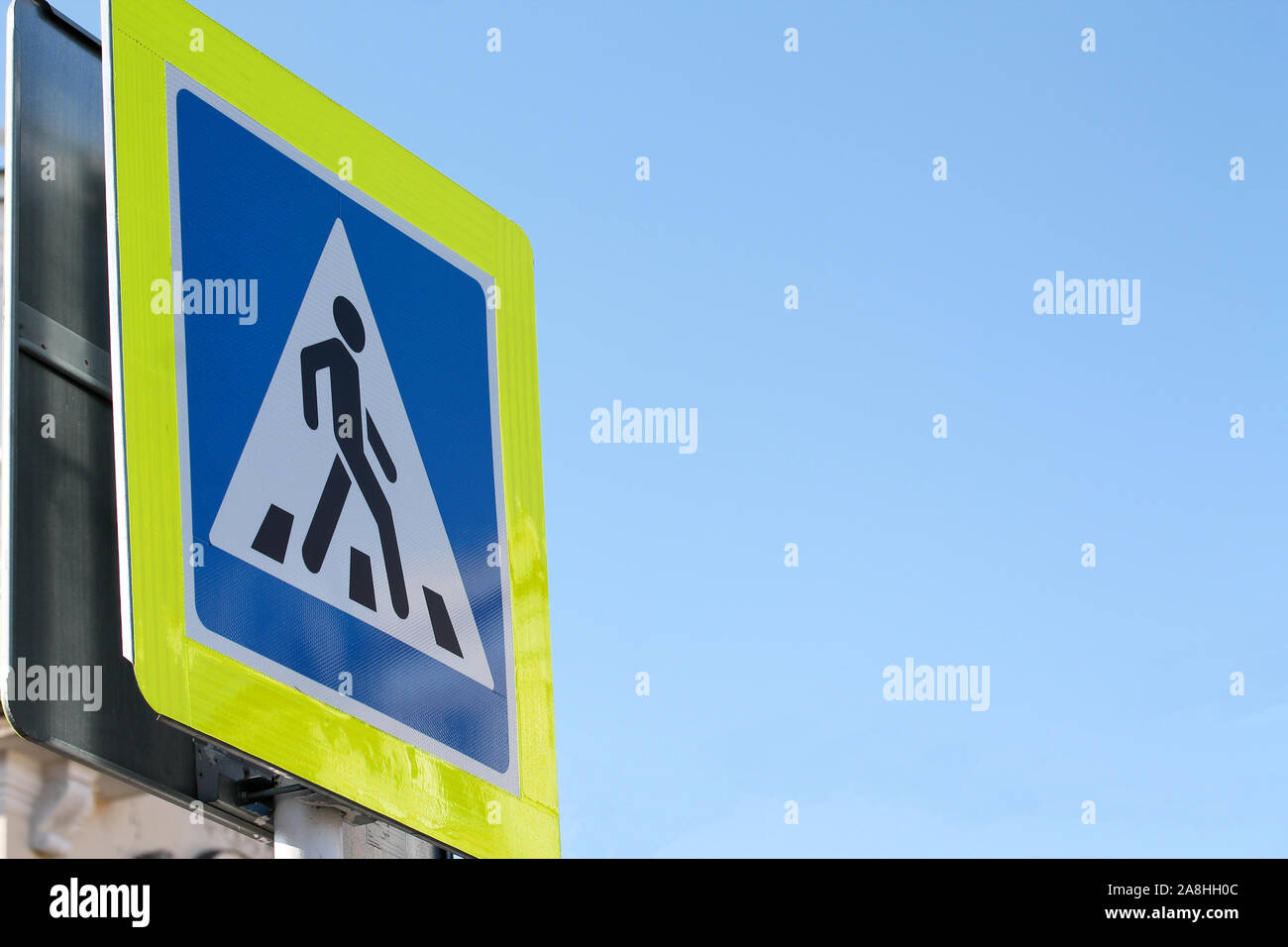 Pedestrian crossing blue sign with yellow light-reflecting frame. Blue ...
