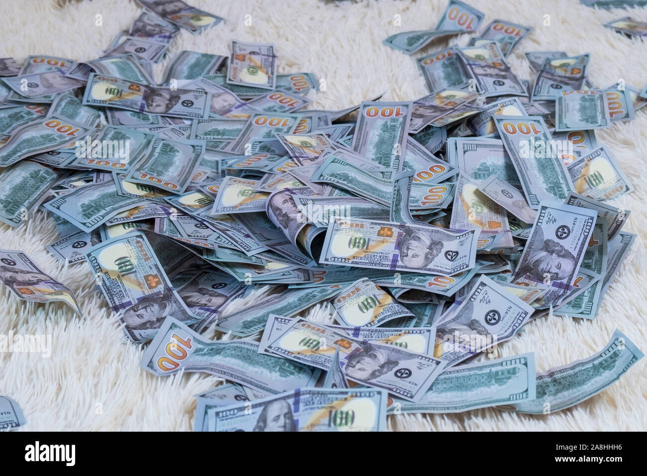 Many banknotes fly in the air on a white bed in slow motion. Huge ...