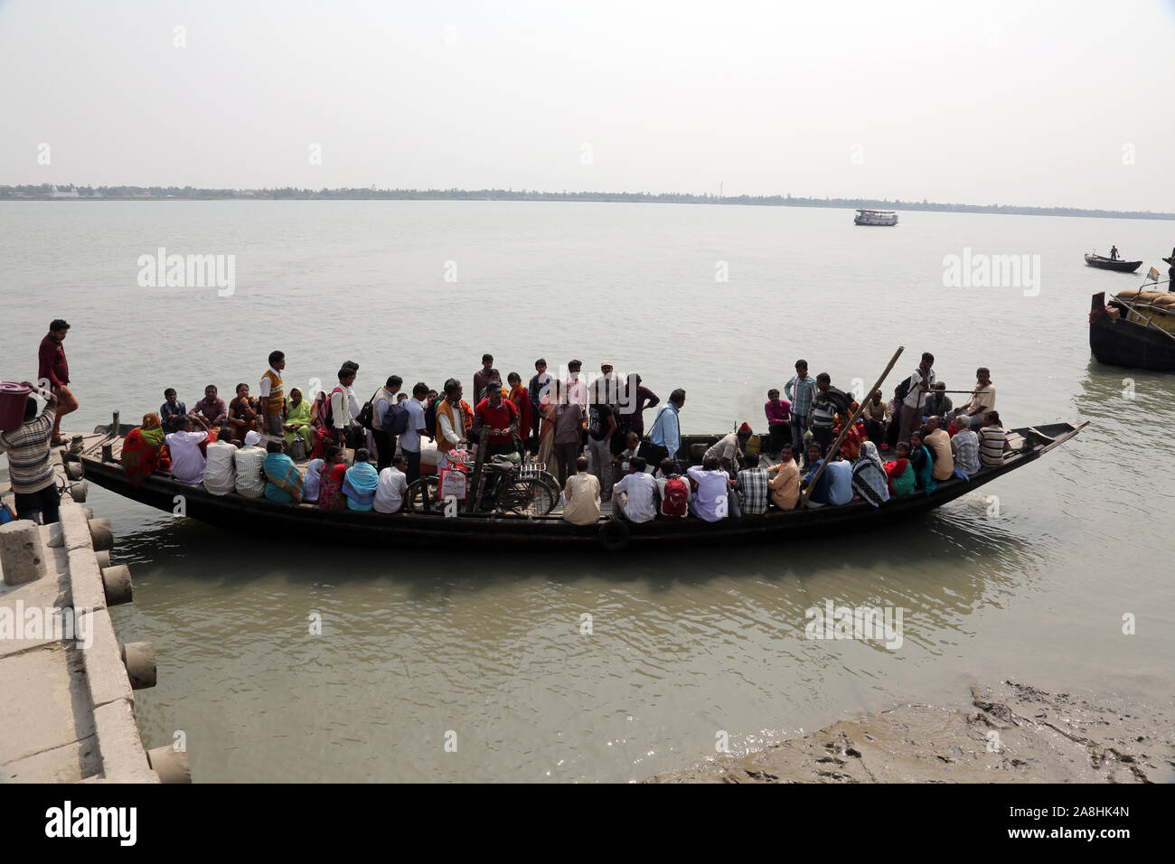 Wooden boat crosses the Ganges River in Gosaba, West Bengal, India ...