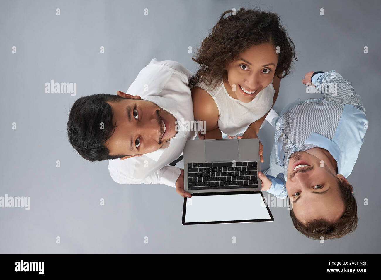 Young people hold on laptop above top view on gray studio background ...