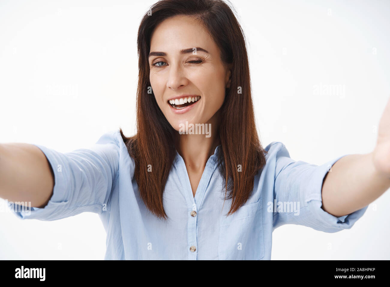 Close-up carefree sassy good-looking tattooed brunette adult woman, taking selfie, hold camera ...