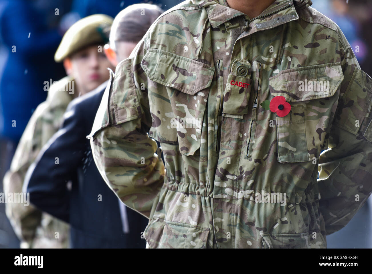 Army cadets stand in front of the war memorial wearing their poppies ...
