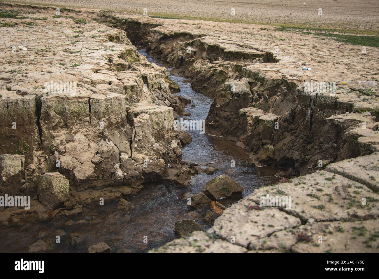 Small river flowing through a desert. Arid dry desert with big cracks ...