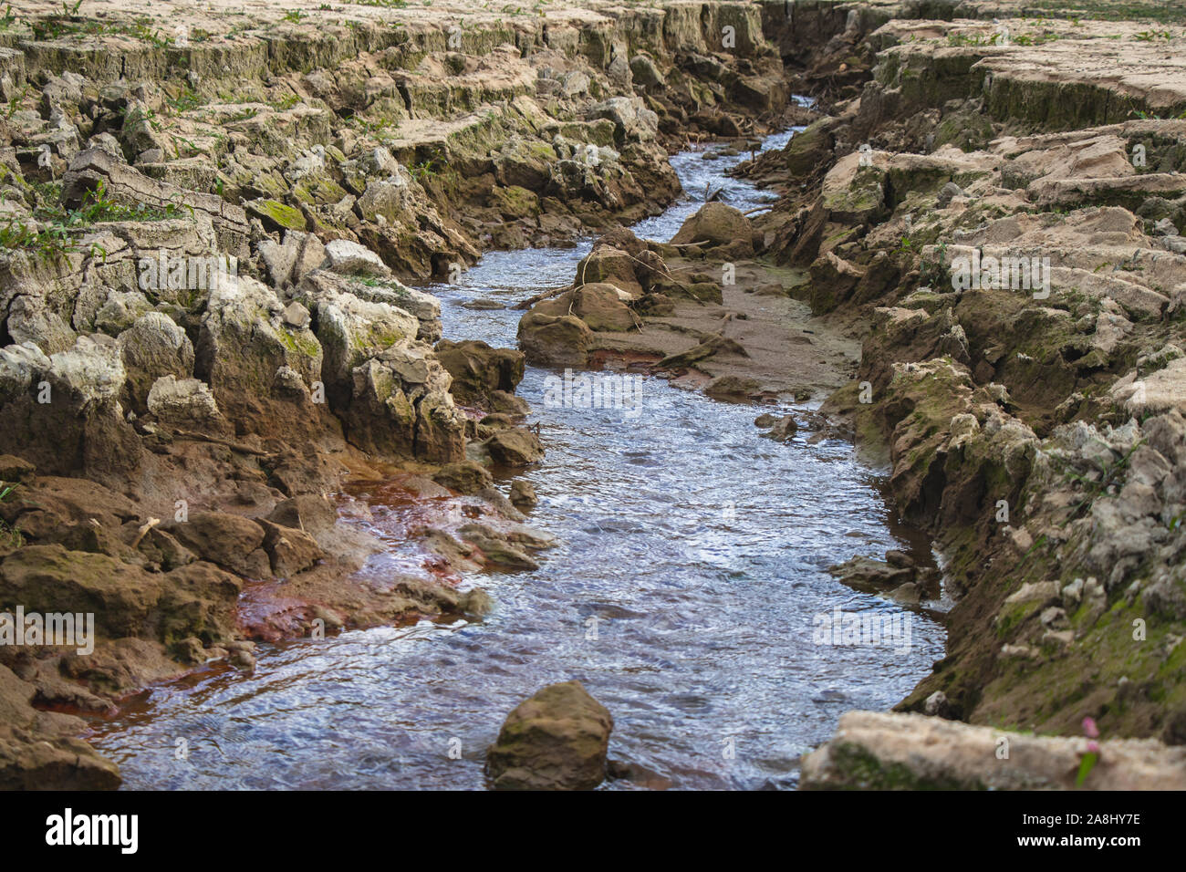 Small river flowing through a desert. Arid dry desert with big cracks ...