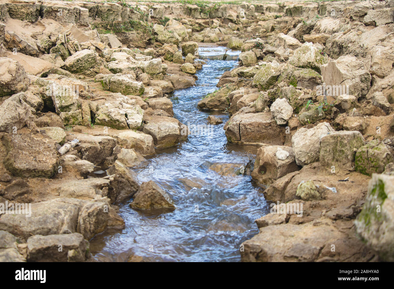 Small river flowing through a desert. Arid dry desert with big cracks ...