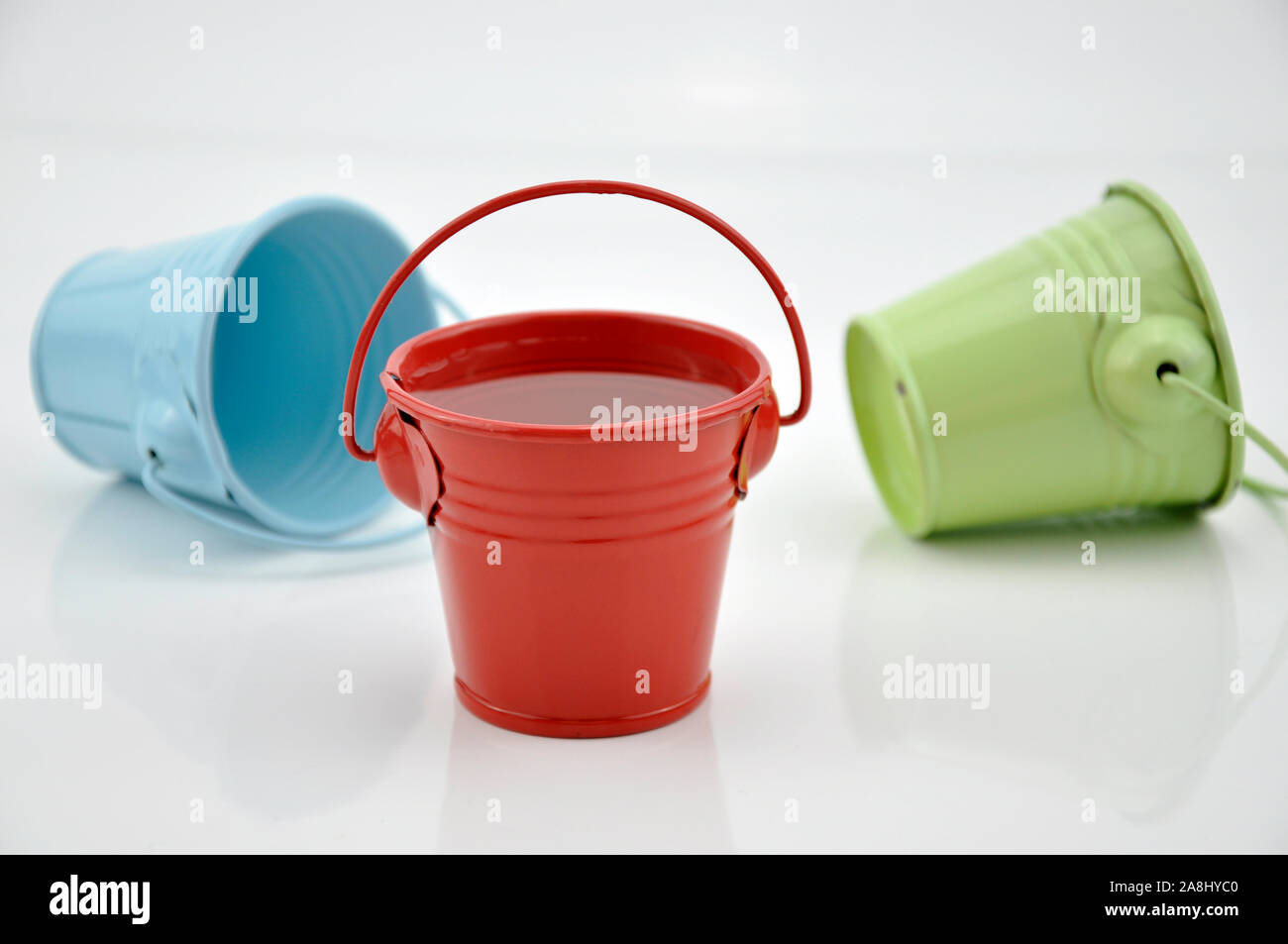 Three metal buckets of different colours with handle, isolated on white ...