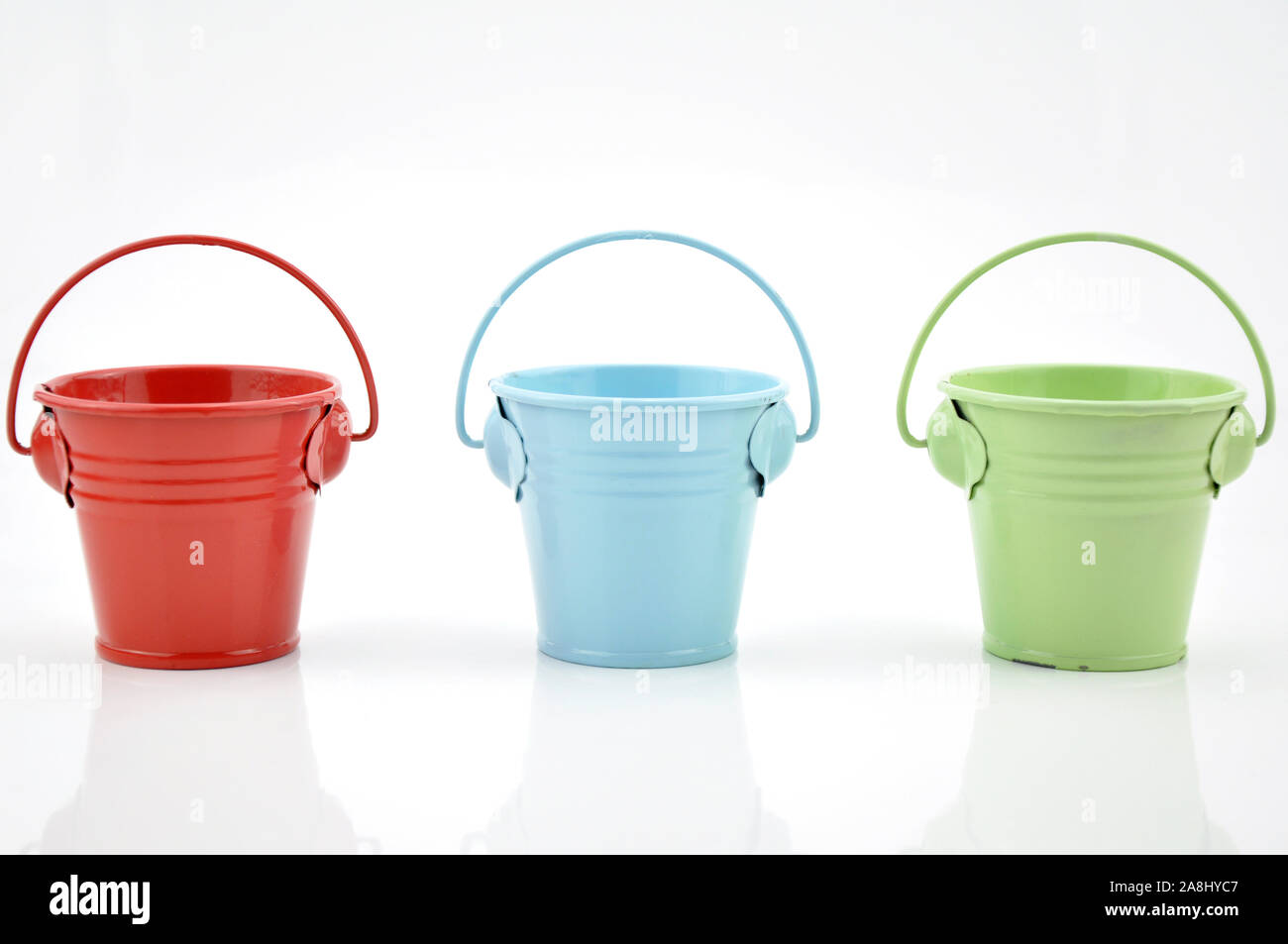 Three metal buckets of different colours with handle, isolated on white ...