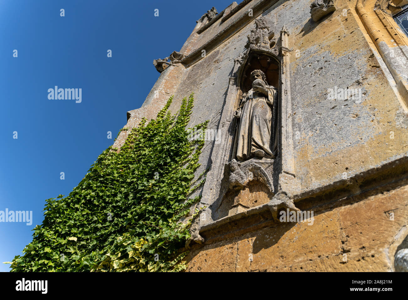 Stock photo of facade of a church with a statue and a vine plant ...