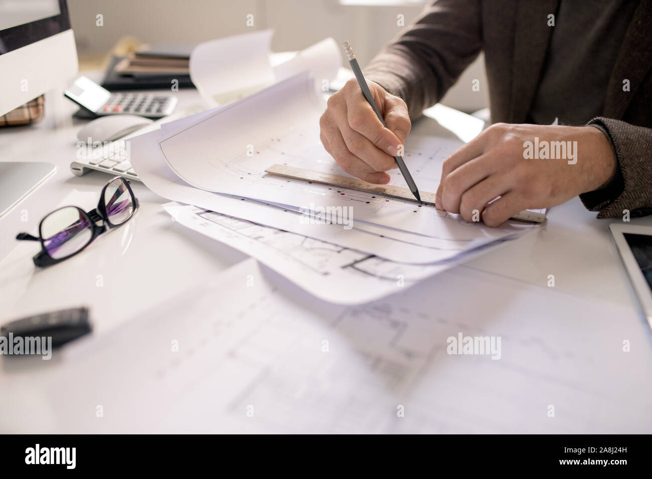 Hands of architect with pencil and ruler drawing line while working ...