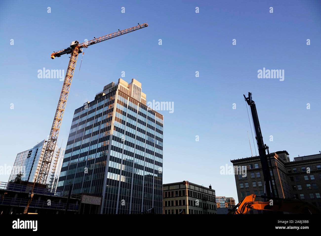 A giant building crane works on a new office building in downtown ...