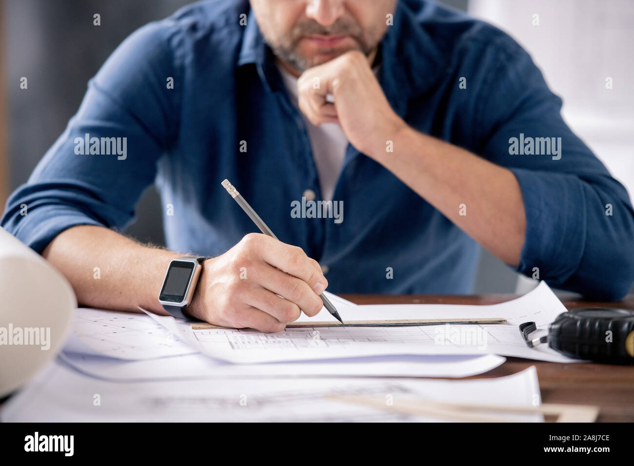 Hands of modern engineer holding pencil over ruler and sketch on ...
