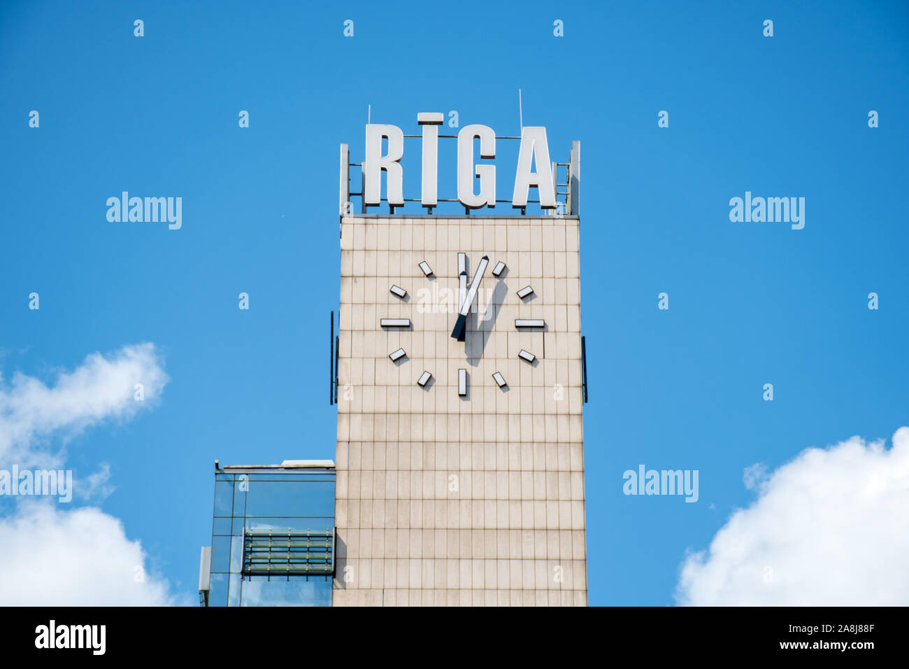 Riga central train station tower with name of the city and clock, blue ...