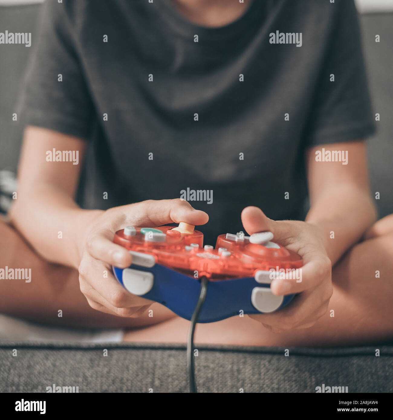 Closeup view of young hands playing with a console remote controller ...