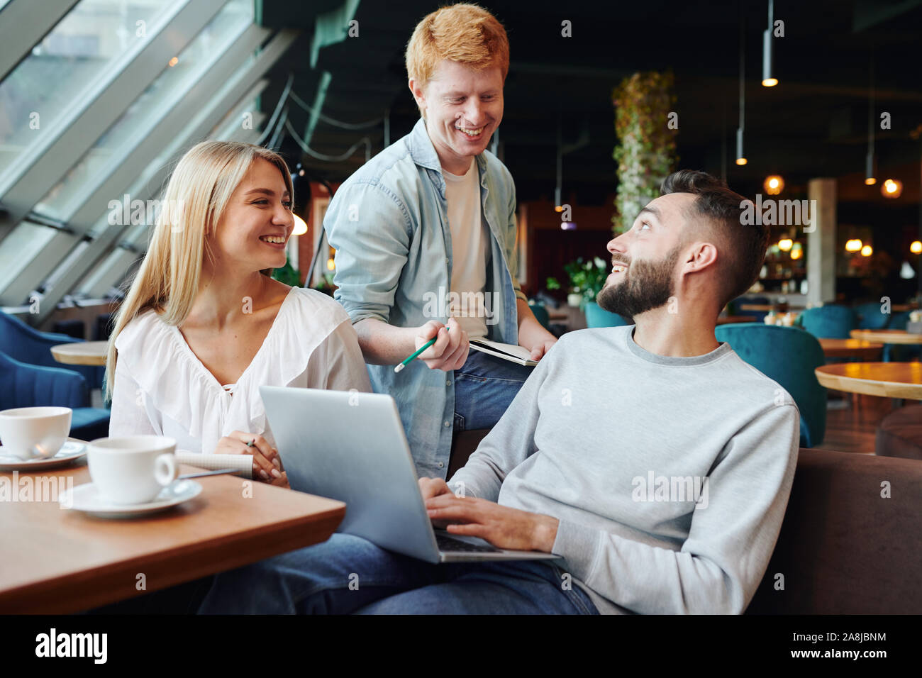 Three Clever College Students Discussing Points Of Presentation For three-clever-college-students-discussing-points-of-presentation-for