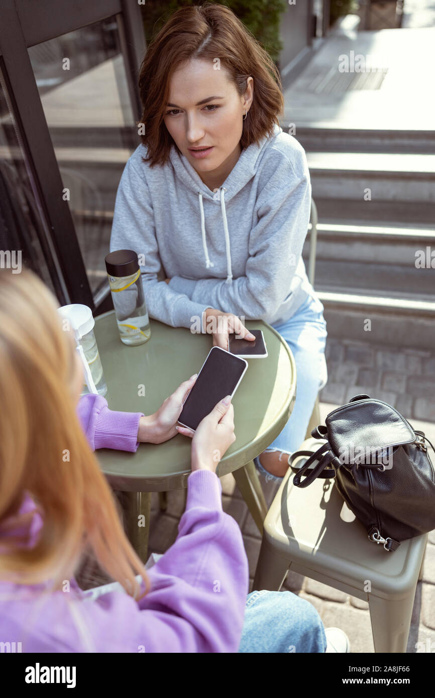 Attentive young female person looking at her friend Stock Photo - Alamy