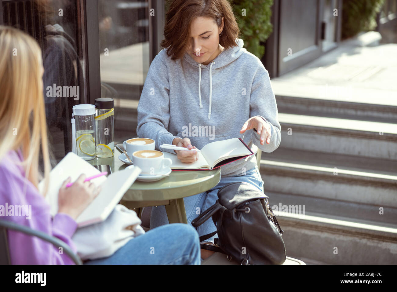 Cute brunette girl making notes into her planner Stock Photo - Alamy