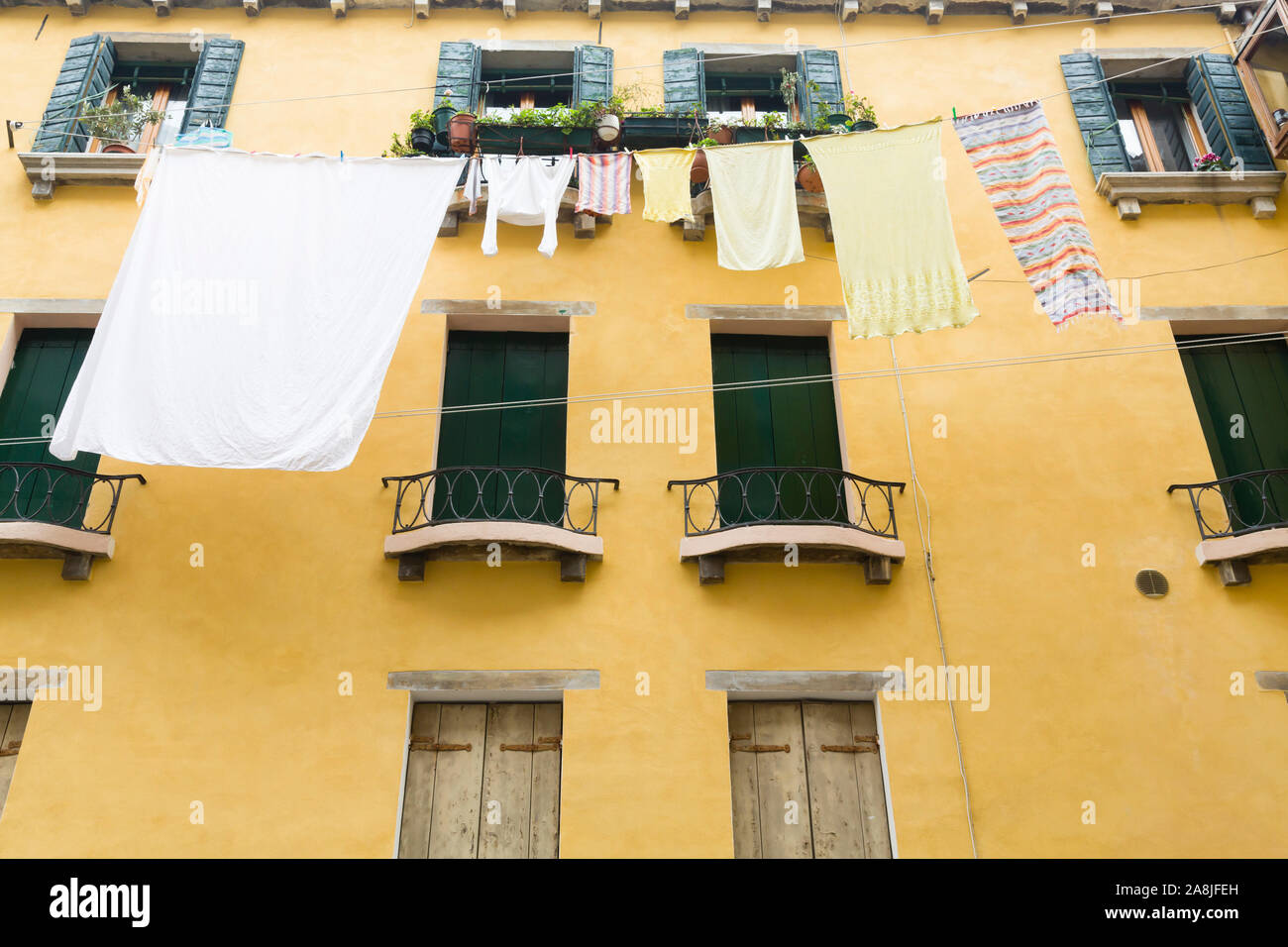 Washing drying airing on a line outside old houses with wooden shutters ...