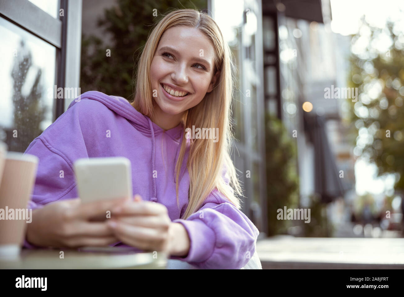 Joyful girl having fun while waiting for coffee Stock Photo - Alamy