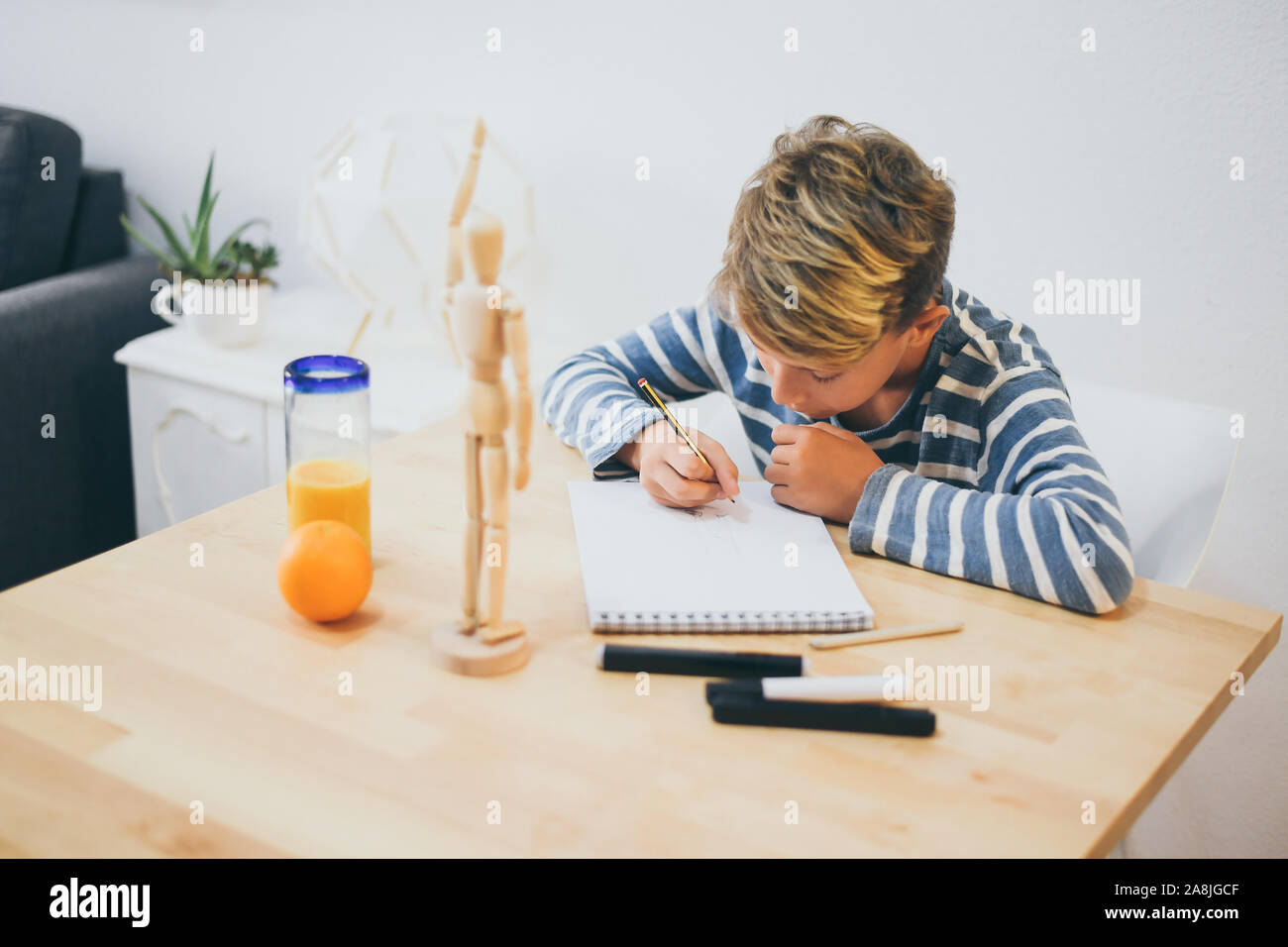 Student drawing with pencil on the notebook. Boy doing homework writing ...
