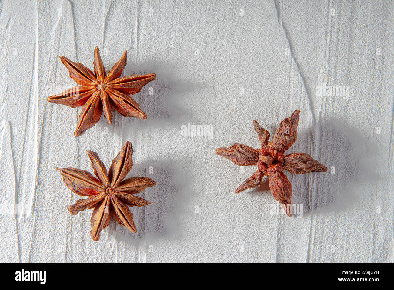 Star anise on a texture background Stock Photo - Alamy
