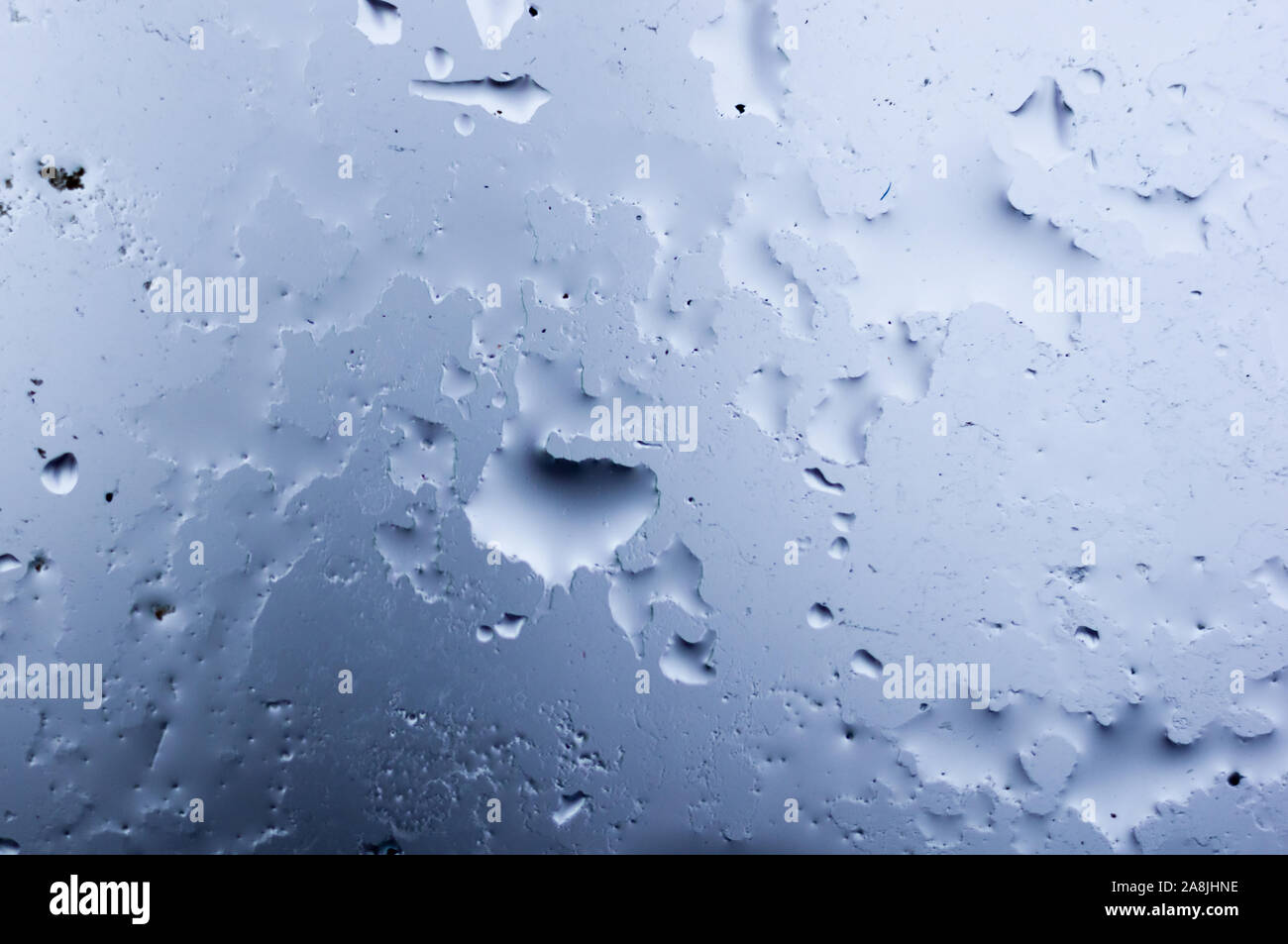 glass in the window covered with wet melting snow, close-up, macro ...