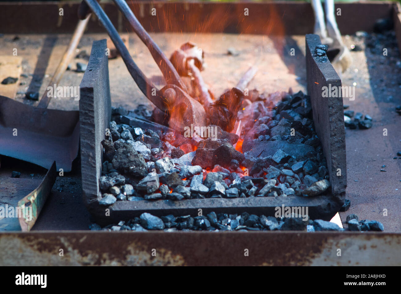 blacksmith furnace with burning coals, tools, and glowing hot metal ...