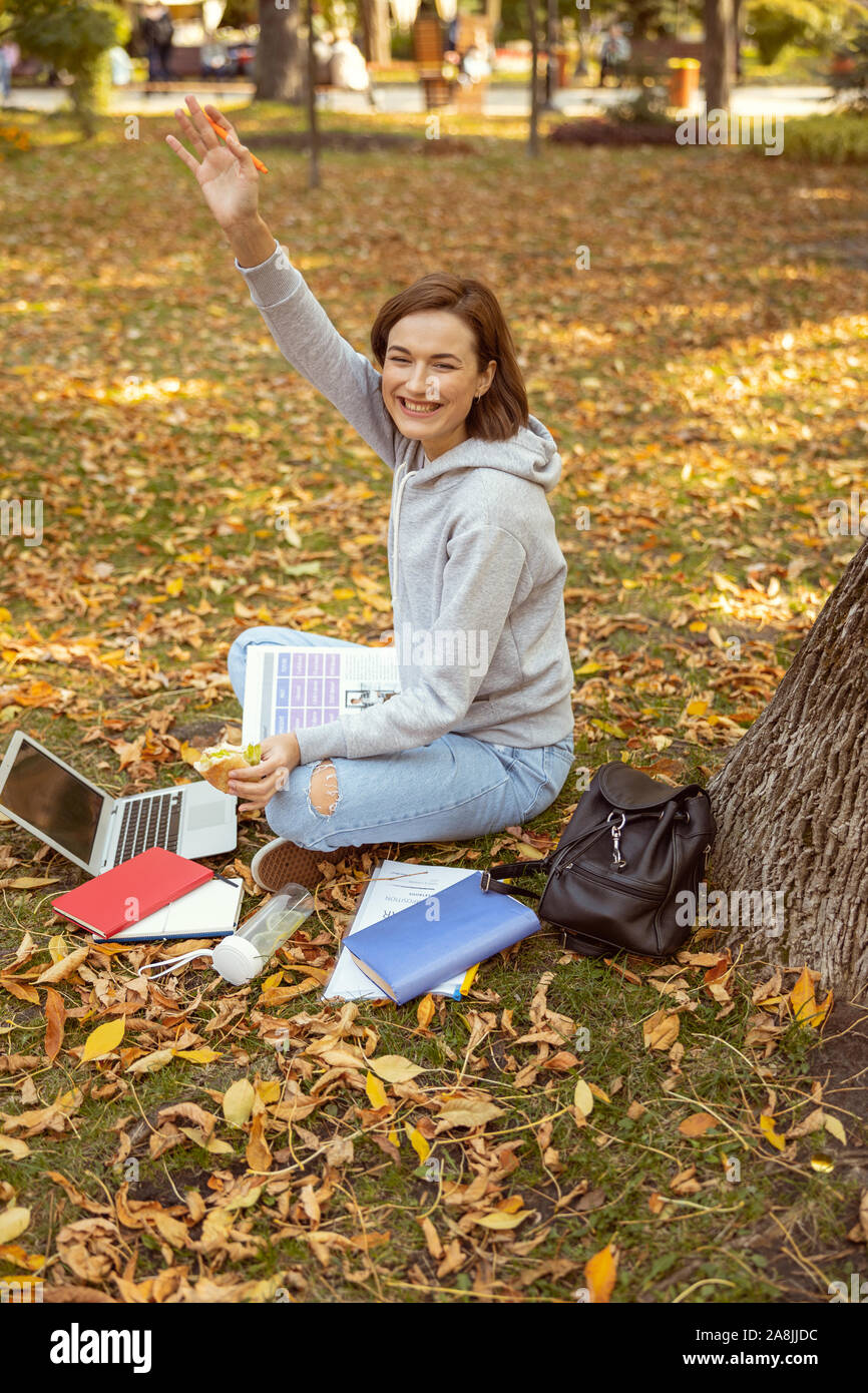 Charming young woman welcoming her group mates Stock Photo - Alamy