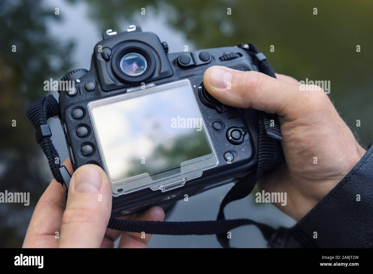 A photographer adjusts the camera. The fingers of the photographer are ...